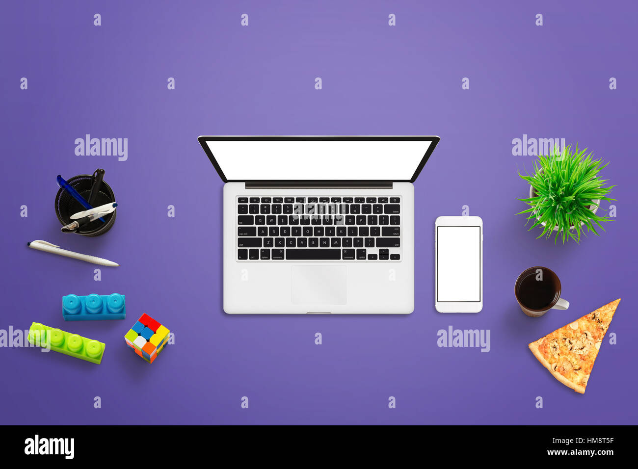 Laptop computer and mobile phone on work desk. Top view of table with ...