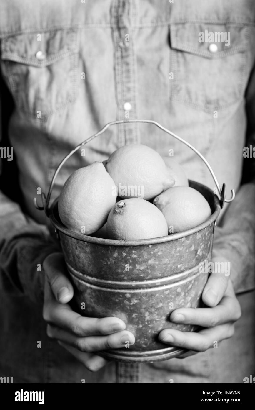 lemons bucket in hands - vegetarian and vegan people Stock Photo - Alamy