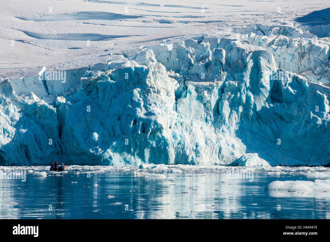 Zodiac with tourists cruising in front of a huge glacier, Hope Bay ...