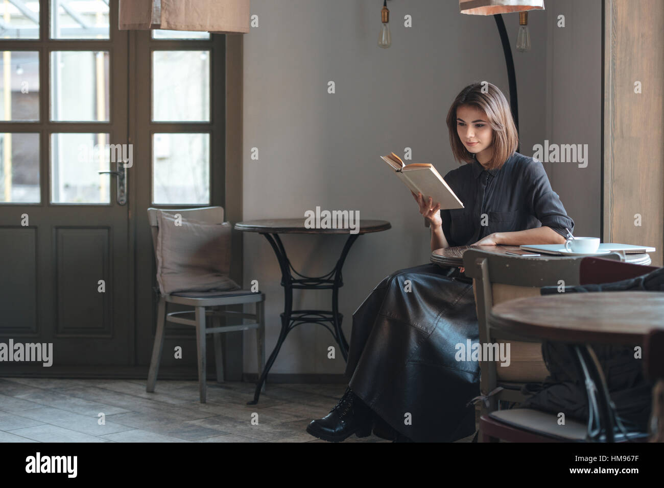 Woman alone reading sitting cafe table hi-res stock photography and ...