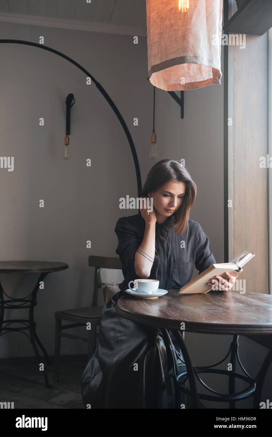 Woman alone reading sitting cafe table hi-res stock photography and ...