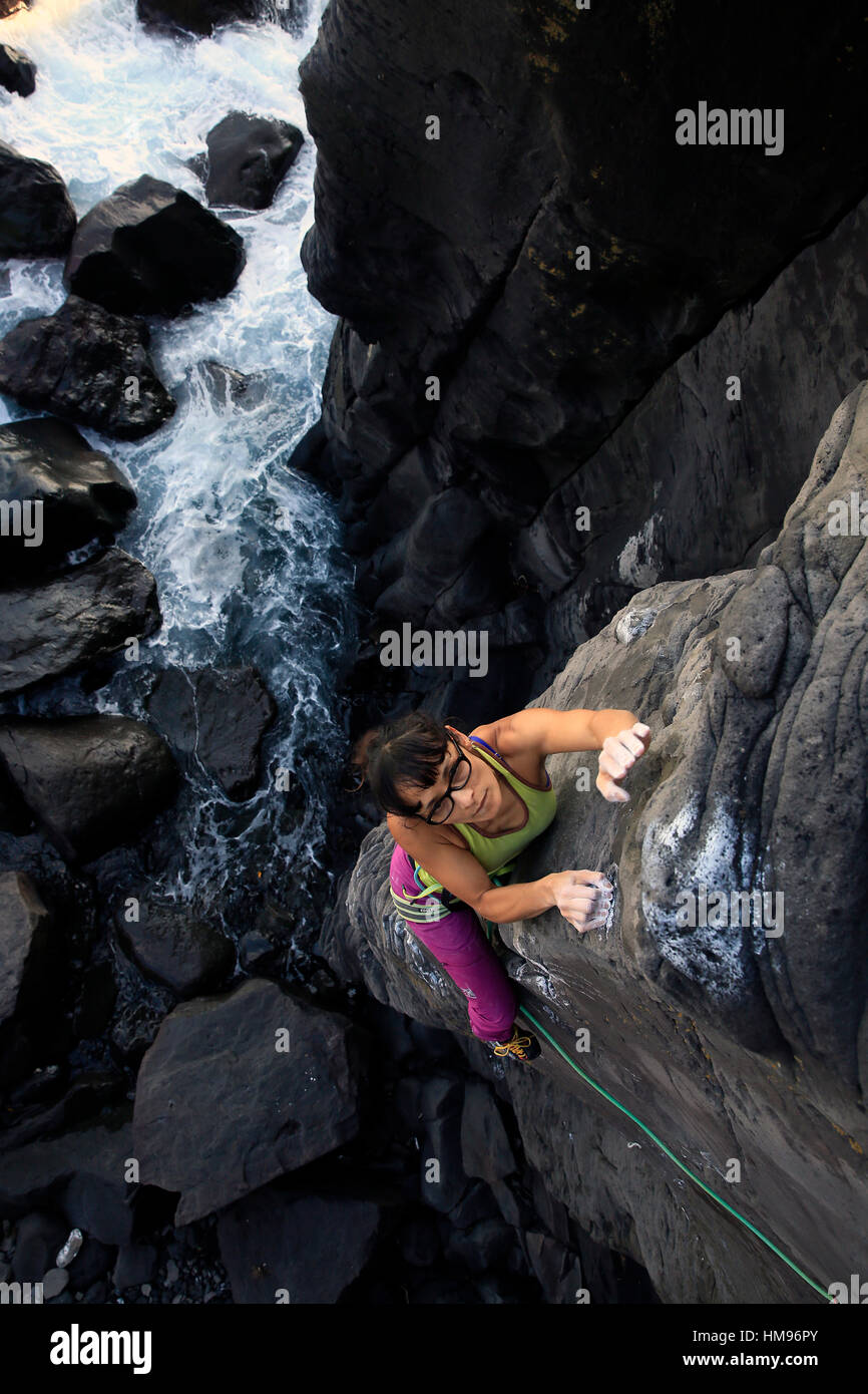 A woman rock climbing on the Jogasaki Coast, Izu Peninsula, Honshu ...