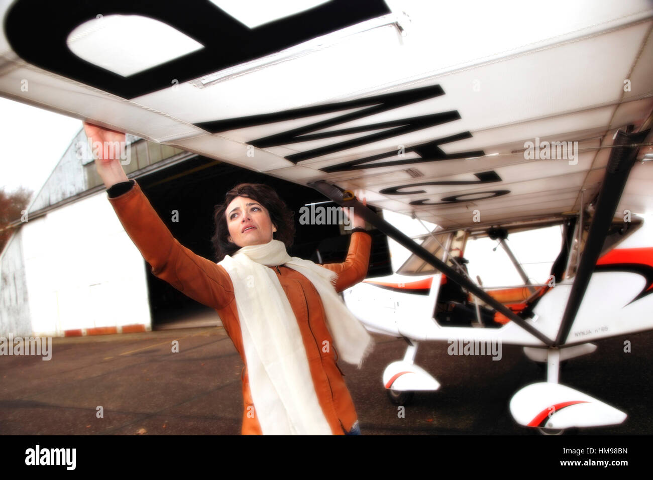 Pilot young woman checking the wing of her microlight Stock Photo - Alamy