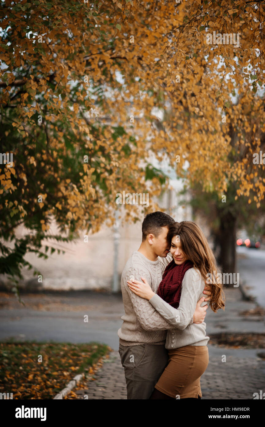 Young couple wearing on tied warm sweaters hugging in love at city in ...