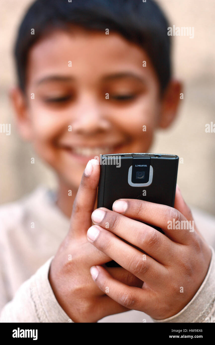 Asian boy playing on mobile phone Stock Photo - Alamy