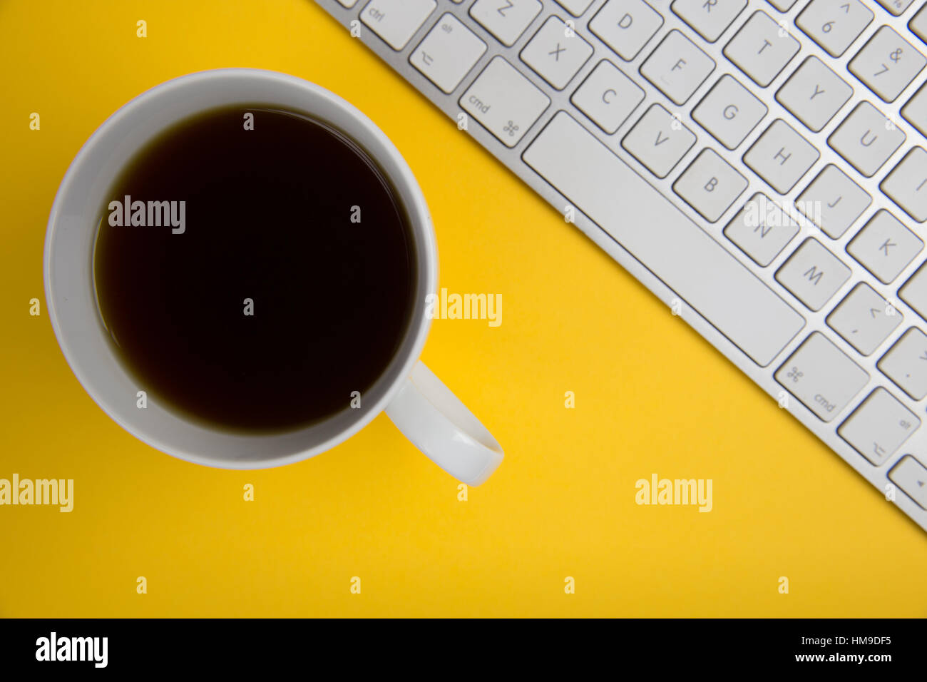 Coffee cup and computer keyboard on yellow background Stock Photo - Alamy