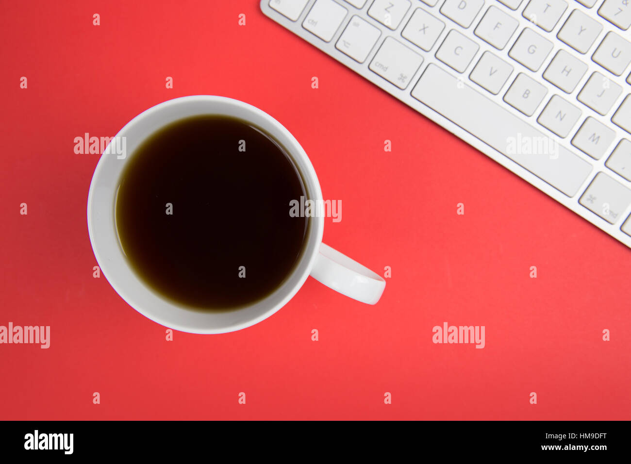 Coffee cup and computer keyboard on red background Stock Photo - Alamy