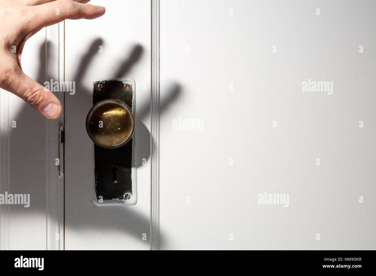 old wooden door with door knob, hand shadow Stock Photo - Alamy