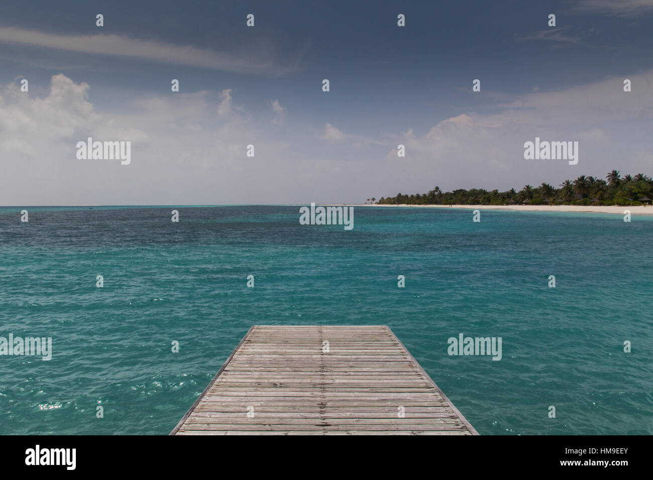 pier in the ocean close to tropical island Stock Photo - Alamy