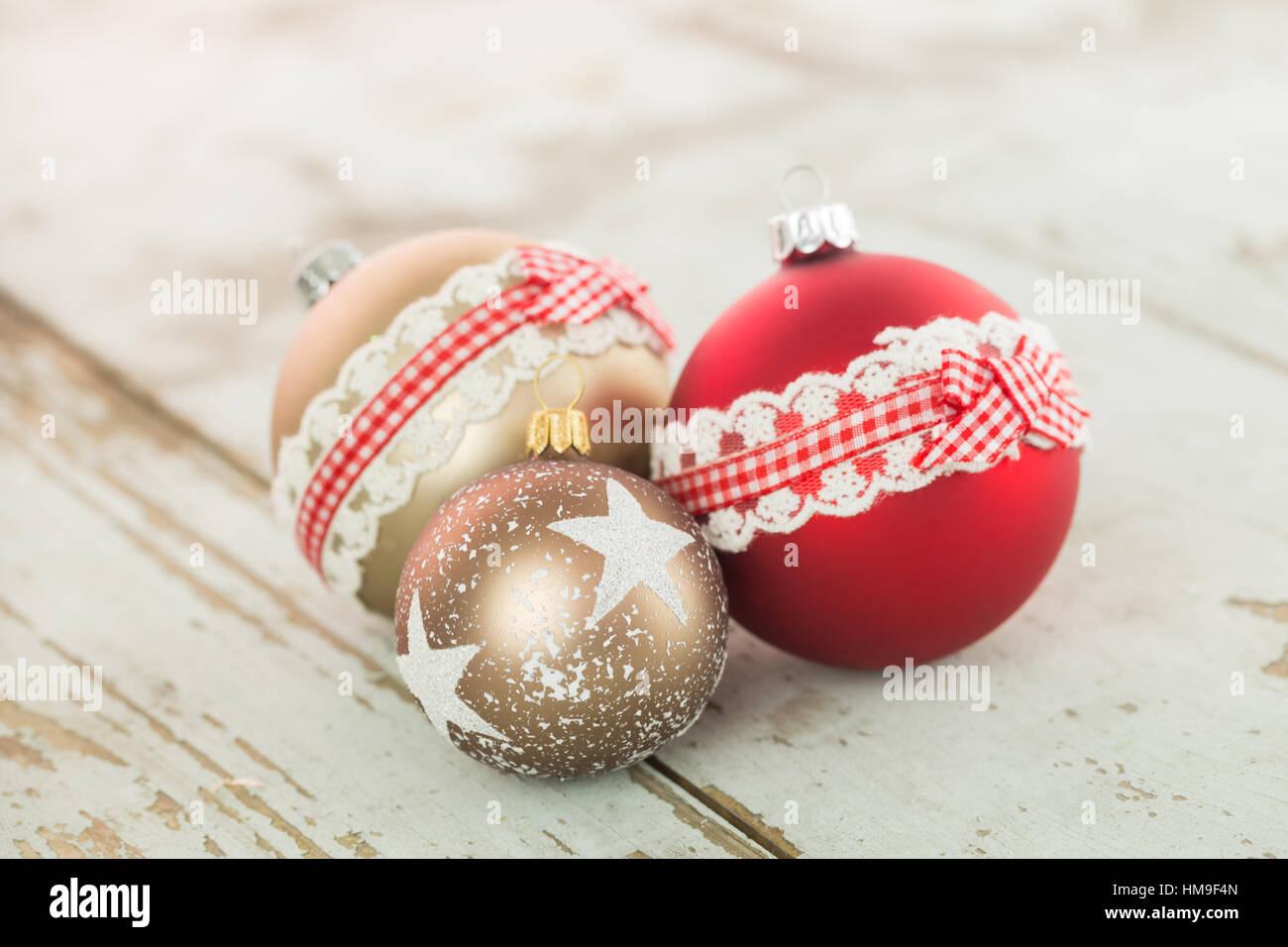 Three colorful decorated Christmas baubles on rustic wood with copy ...