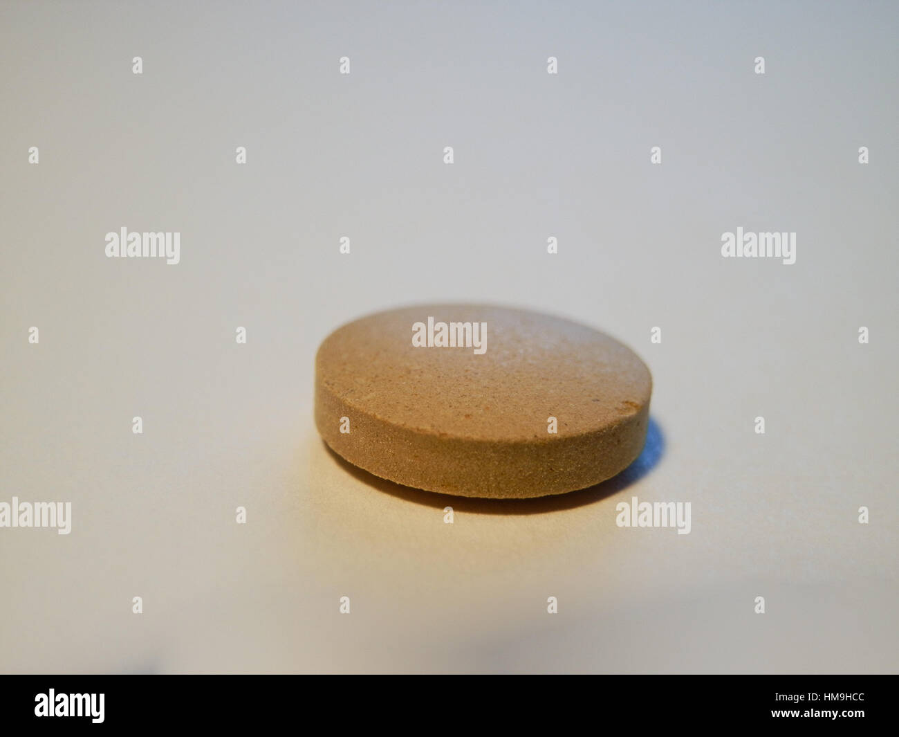 Single medicine drug pill brown round one Stock Photo - Alamy