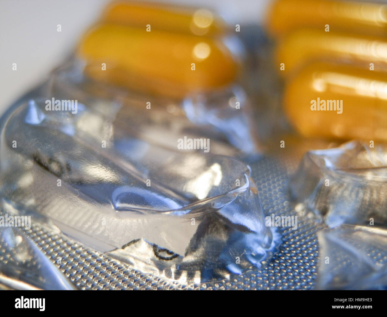 Pack of yellow pill drugs 1 eaten Stock Photo - Alamy