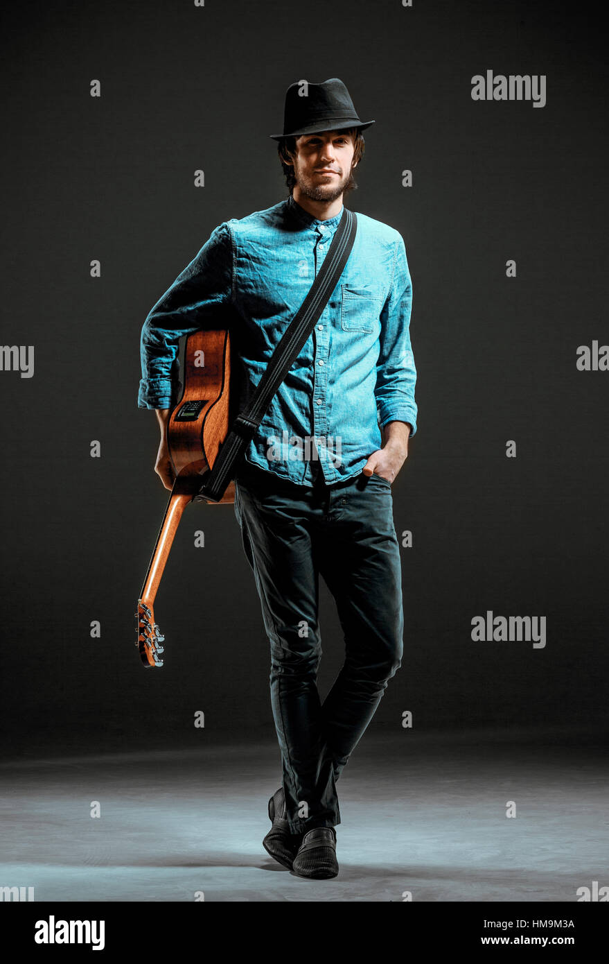 Cool guy standing with guitar on dark background Stock Photo - Alamy