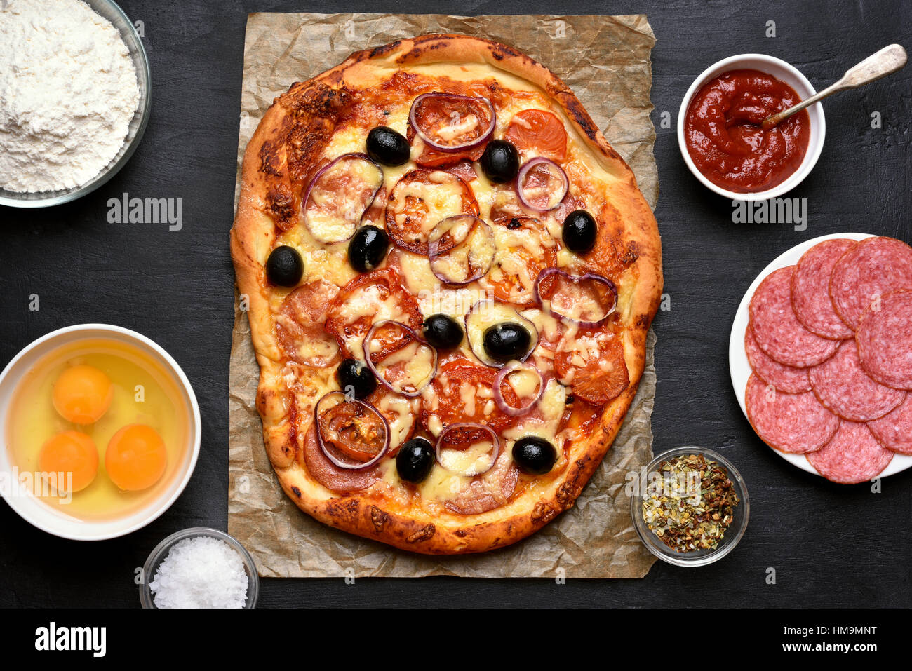 Pizza and ingredients on dark background, top view Stock Photo - Alamy