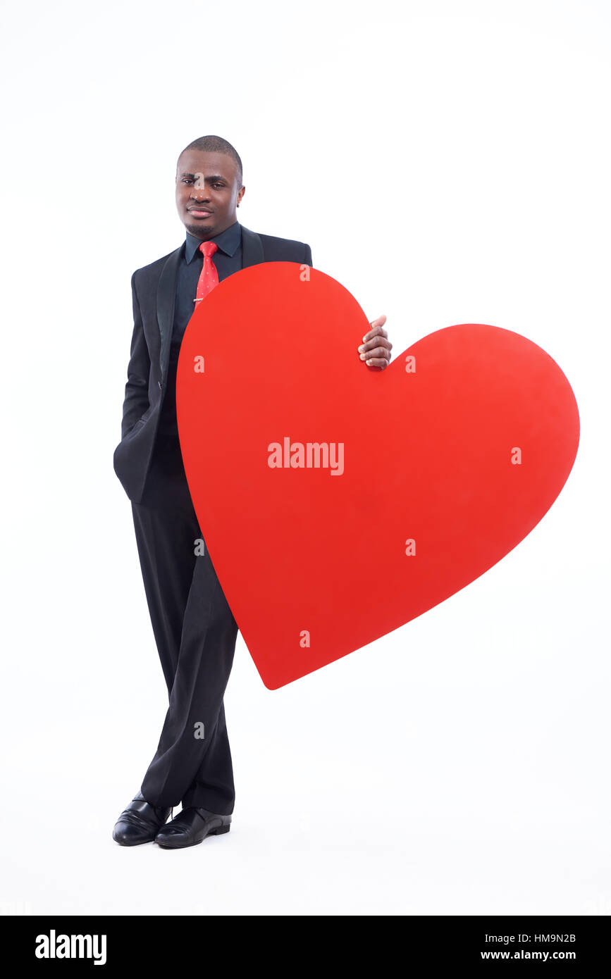 Serious man holding big heart, symbol of love Stock Photo - Alamy