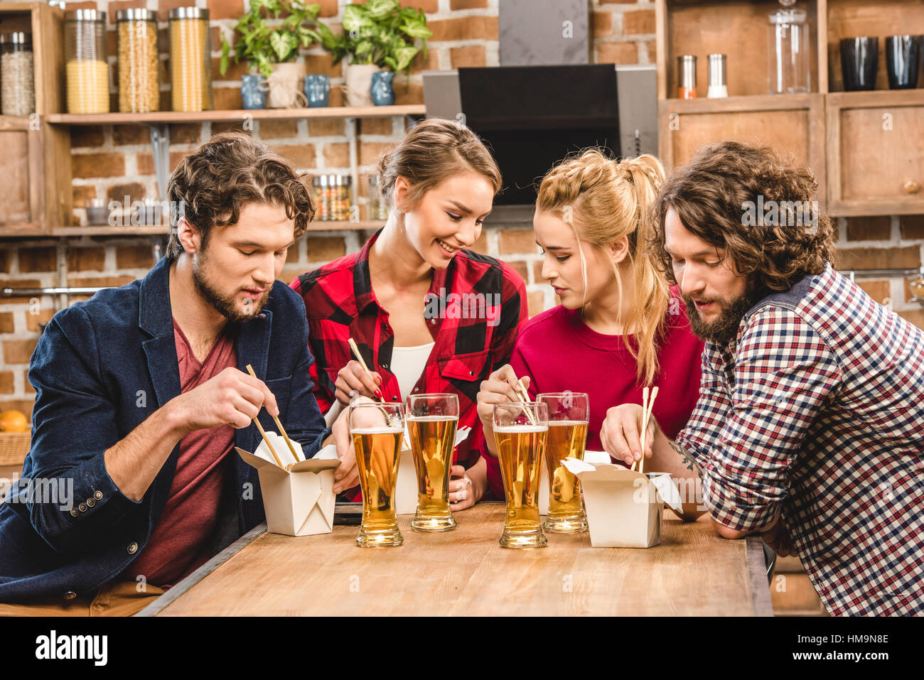 Friends eating noodles Stock Photo - Alamy