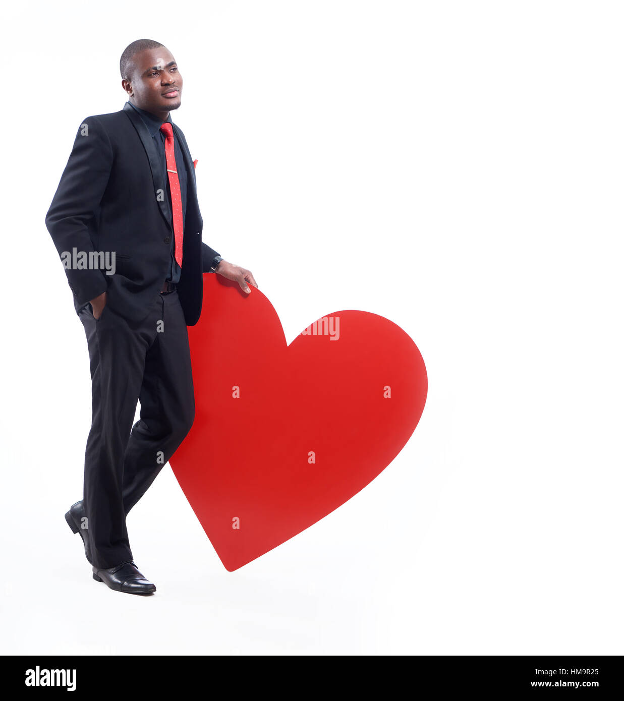Business man posing and leaning of big heart Stock Photo - Alamy