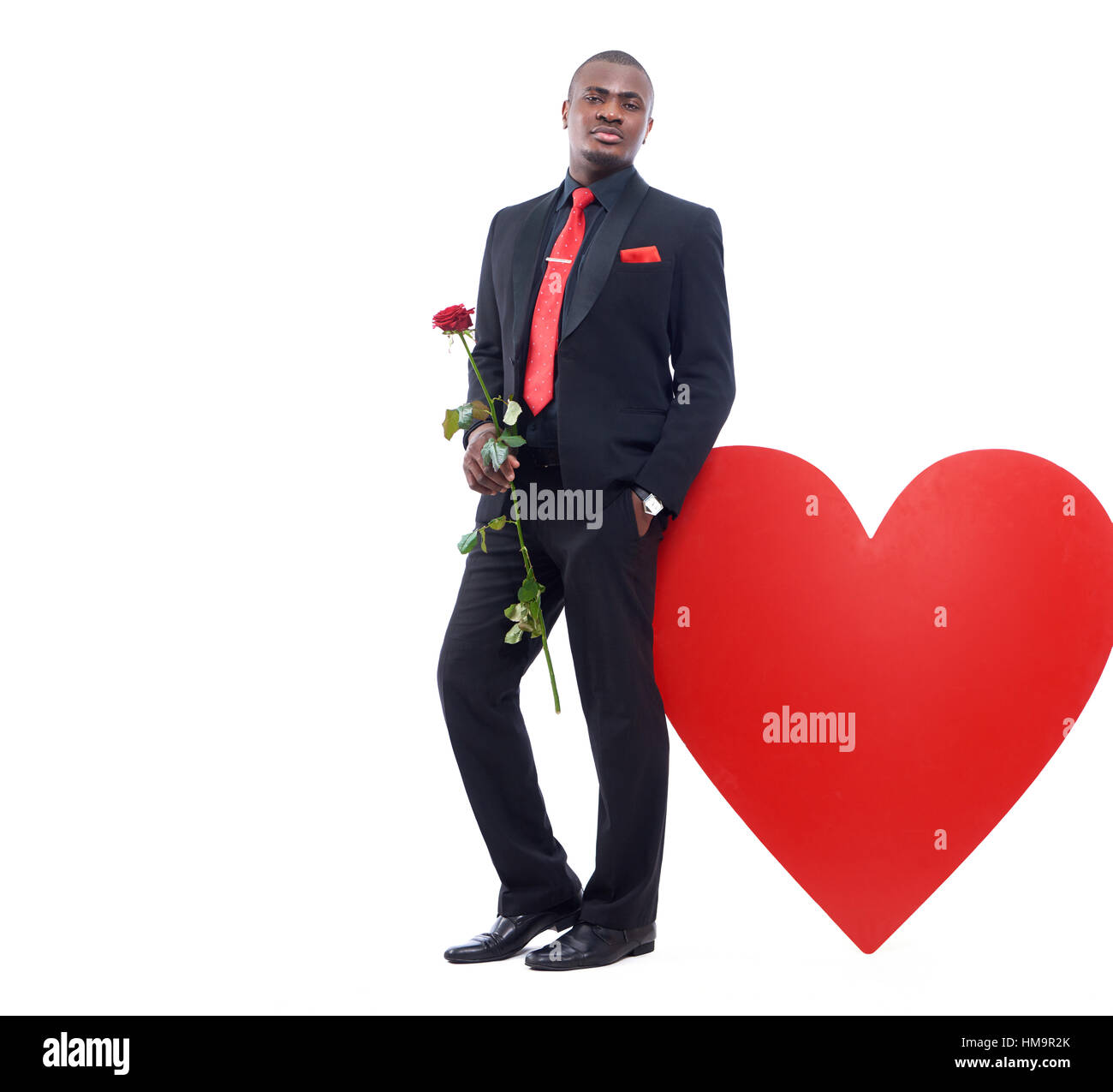 Man holding red rose and posing at studio Stock Photo - Alamy