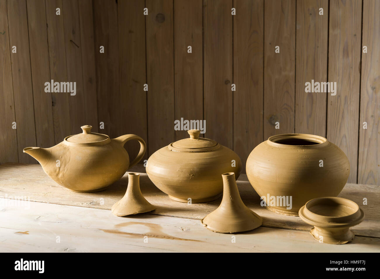 Ceramic workshop, leather-hard pots in three stages on workbench ...