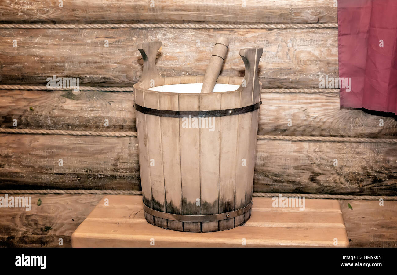 The interior of a small bath with wooden walls. On the bench a barrel ...