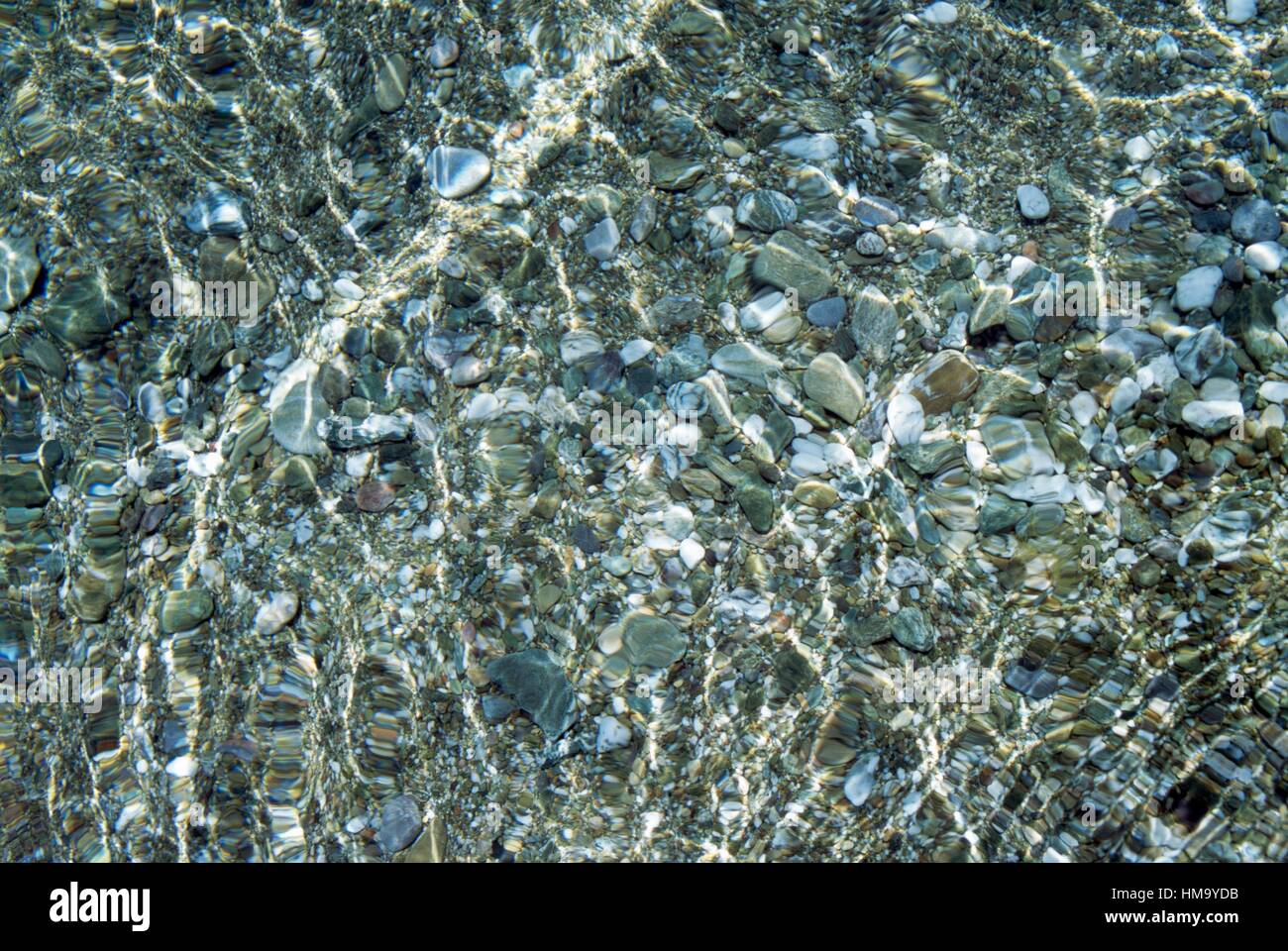 Water reflecting on a sea-bed with rocks and gravel, near Itanos, Crete ...