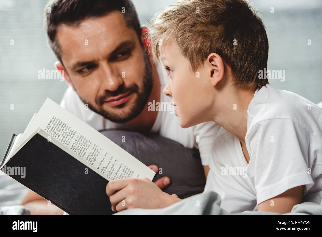 Father and son reading book Stock Photo - Alamy