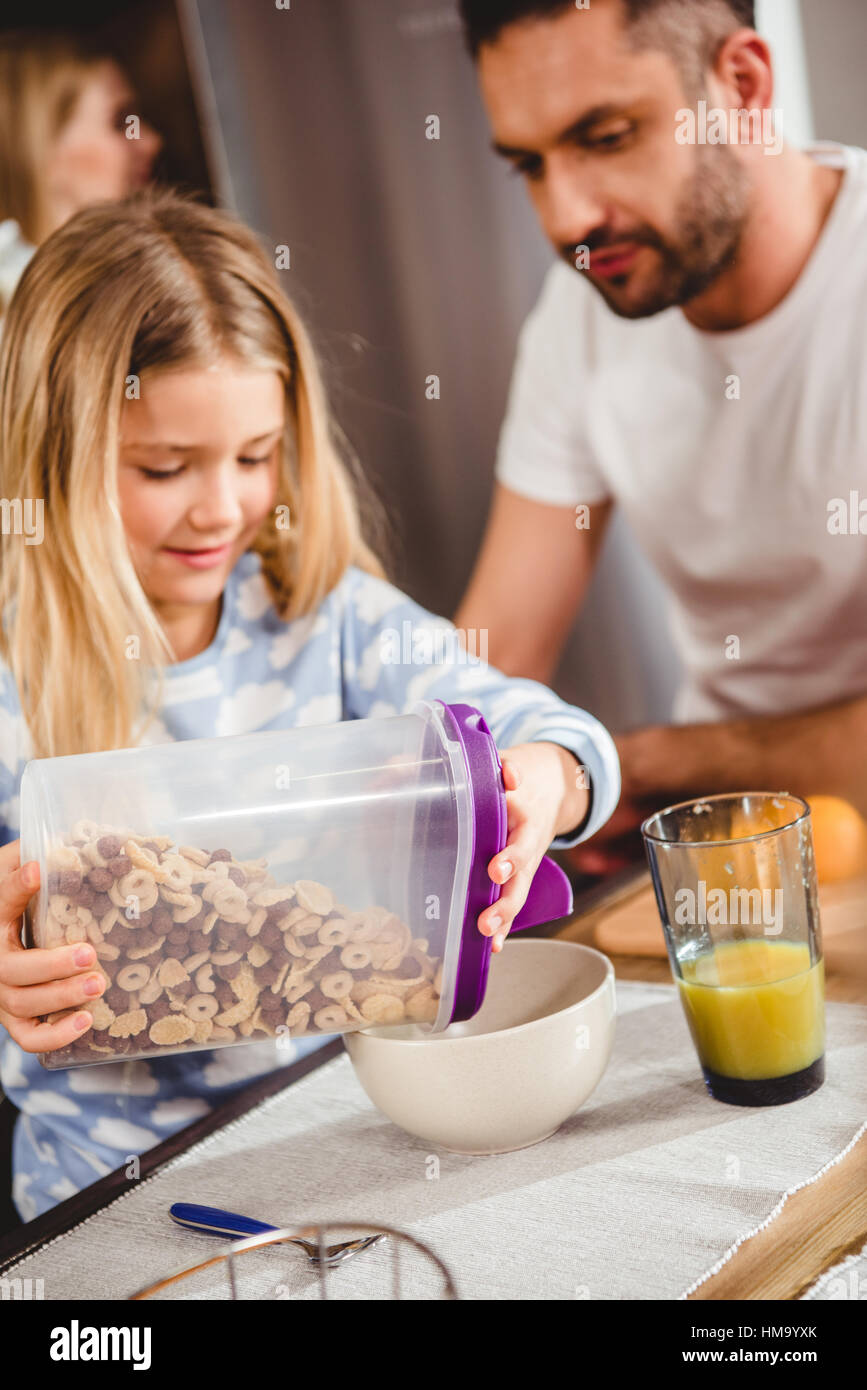 Girl pours corn flake rings Stock Photo - Alamy