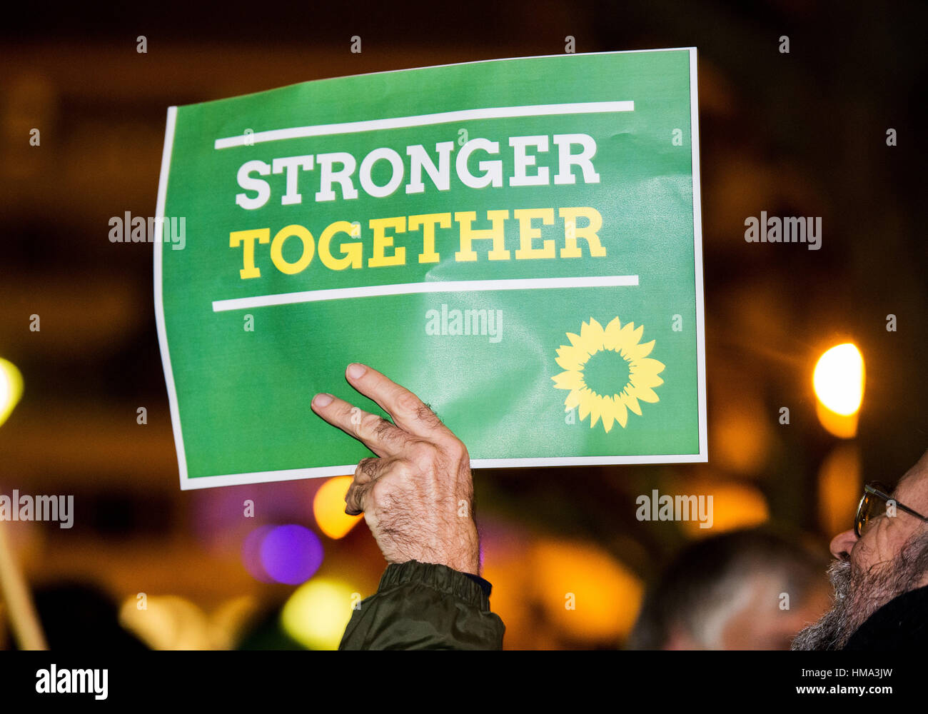 A protestor holds up a sign reading "Stronger Together" at the ...