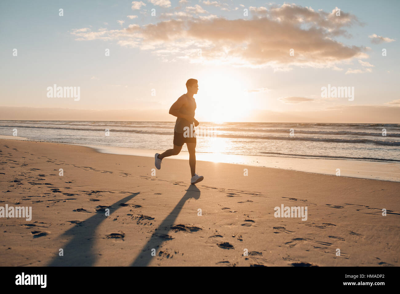 Man running along the beach hi-res stock photography and images - Alamy