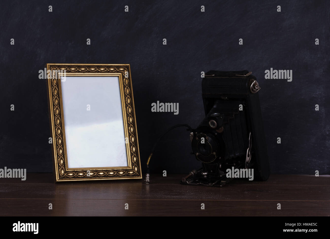 Old vintage camera and frame against blackboard background Stock Photo ...