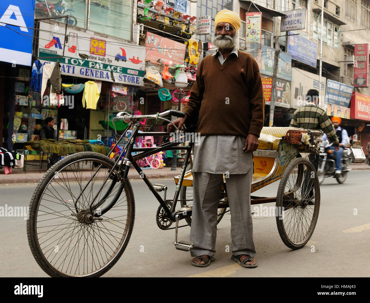INDIA, AMRITSAR - NOVEMBER 29: Rickshaw driver with one's rickshaw in ...