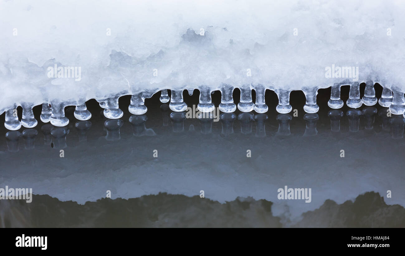 Small round icicles over water Stock Photo - Alamy