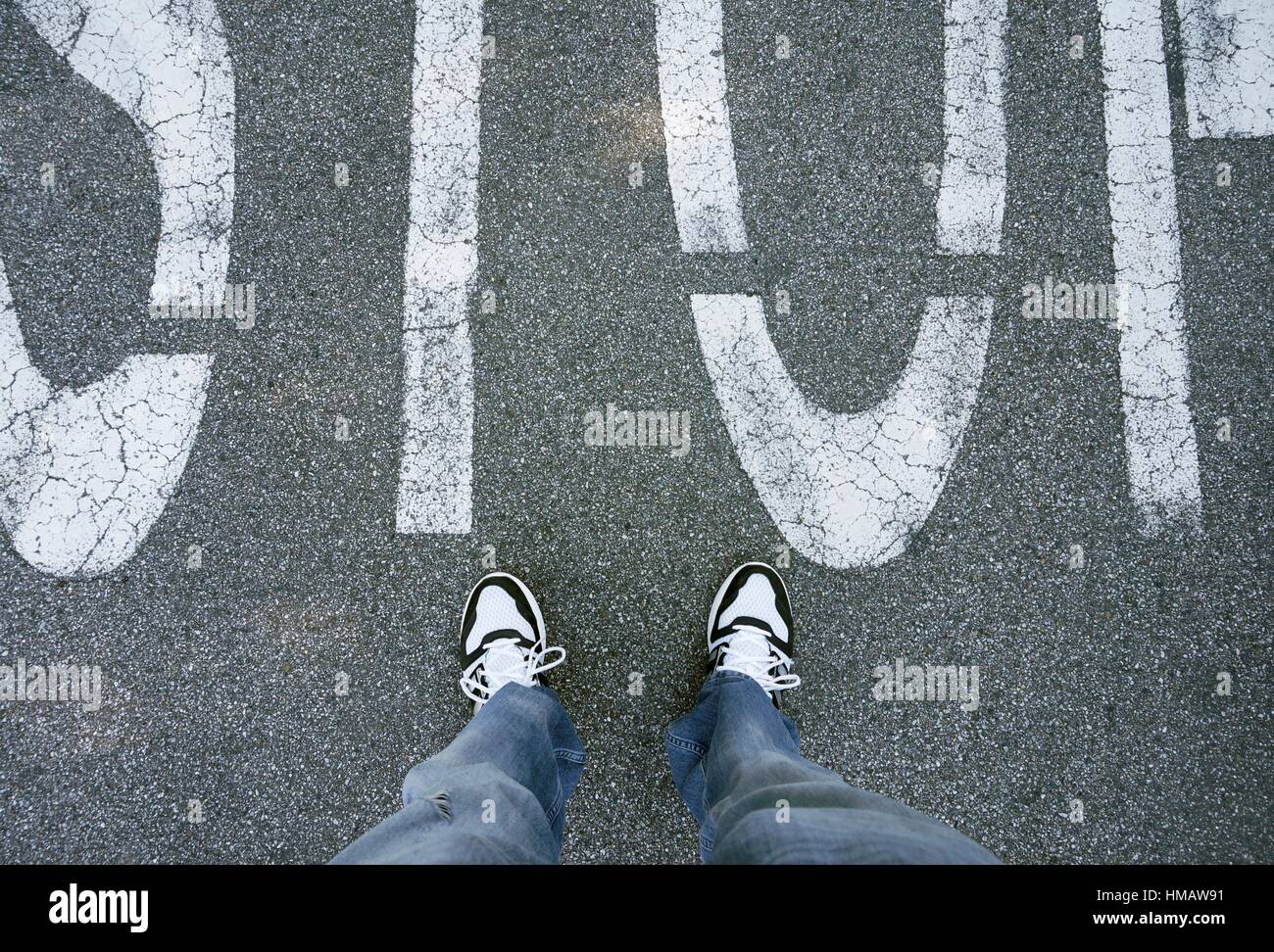 Male feet standing on asphalt with stop sign marking Stock Photo - Alamy