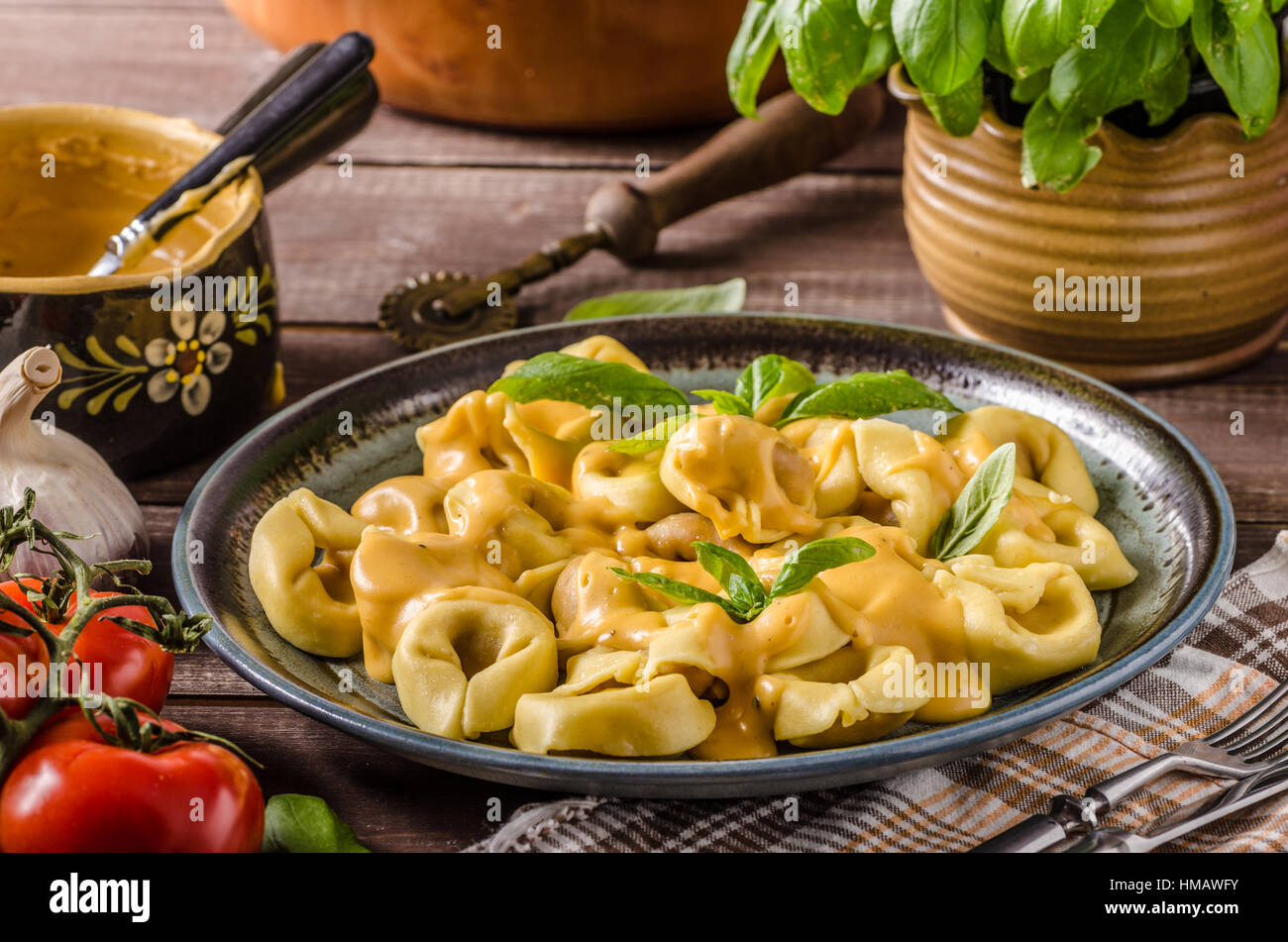 Tortellini with cheese sauce, basil and herbs Stock Photo - Alamy