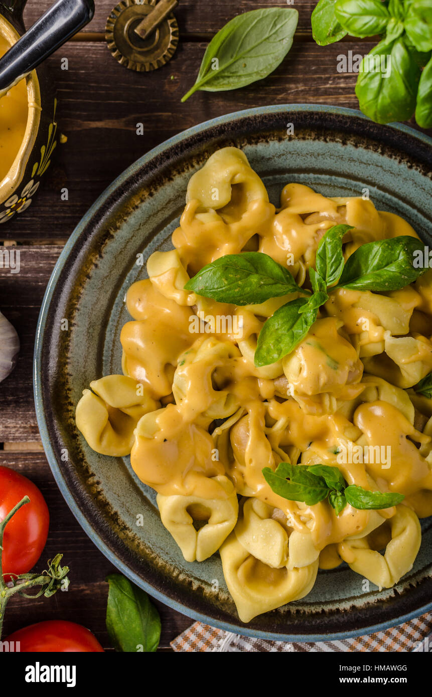 Tortellini with cheese sauce, basil and herbs Stock Photo - Alamy