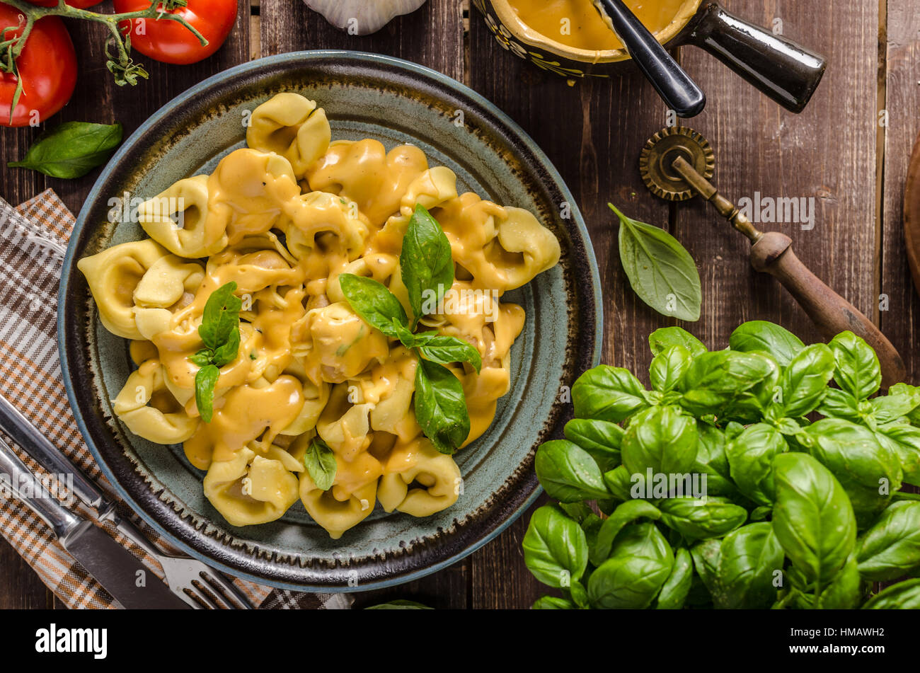 Tortellini with cheese sauce, basil and herbs Stock Photo - Alamy