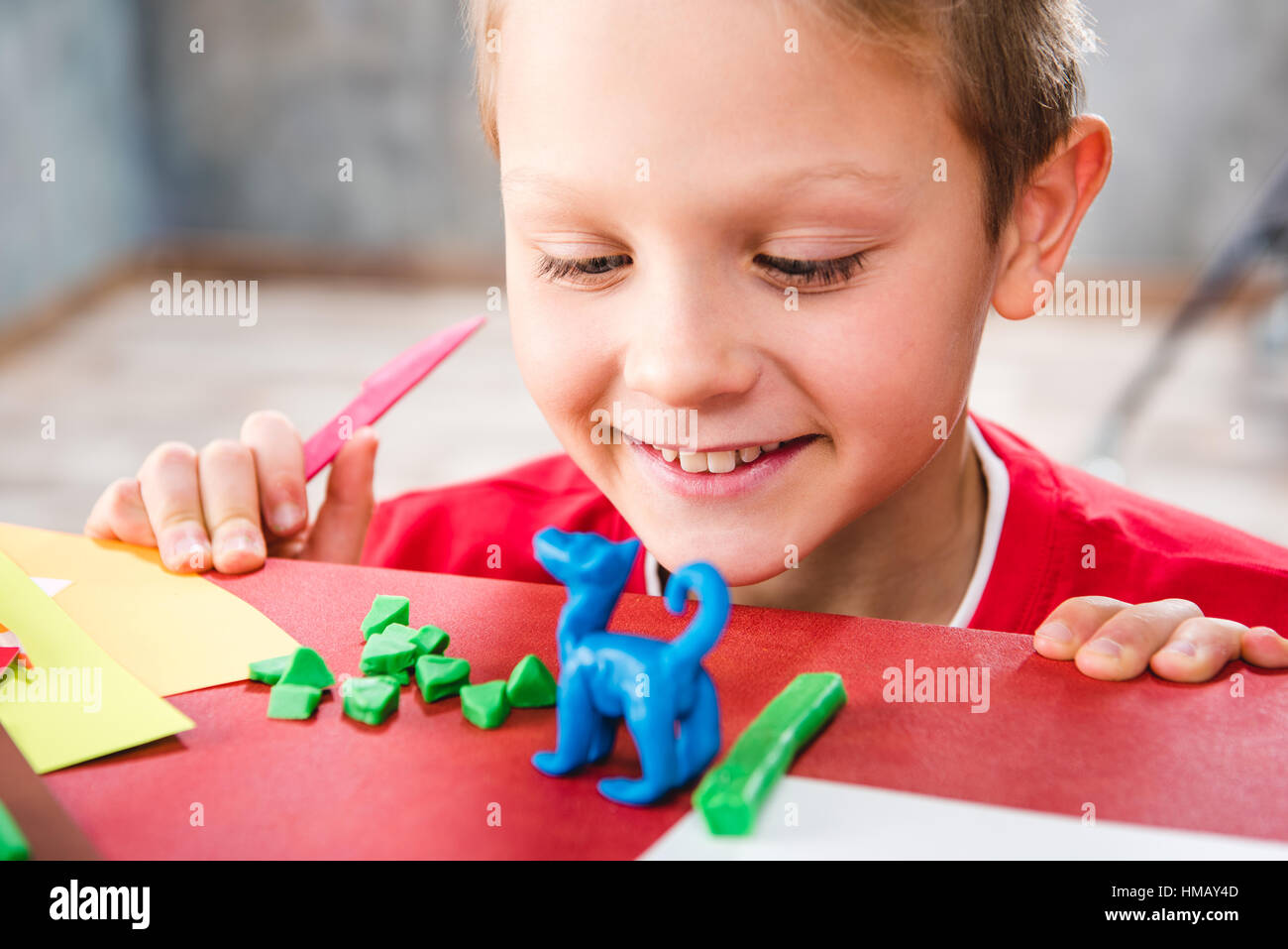 Schoolchild making toy from plasticine Stock Photo - Alamy