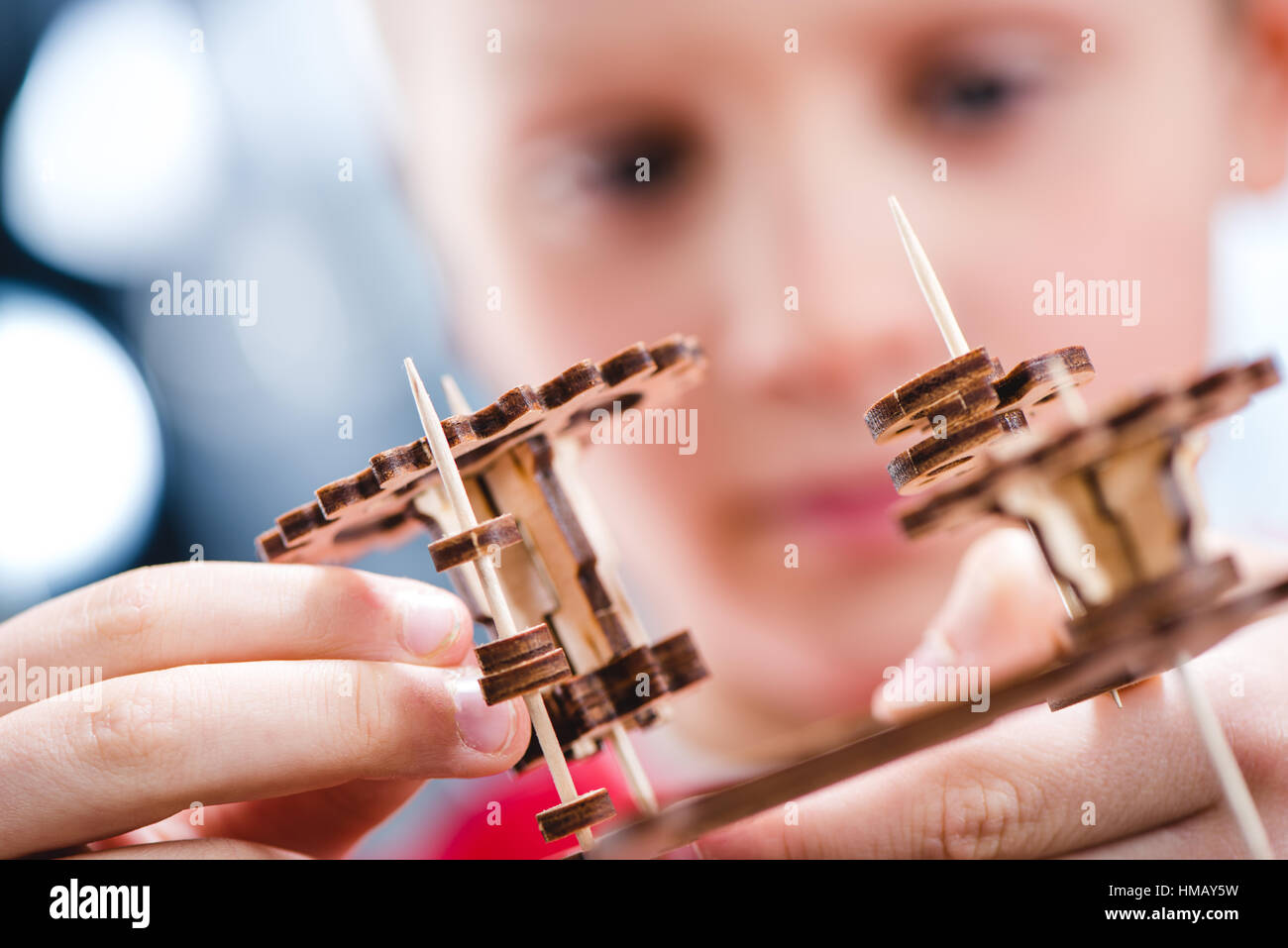 Kid holding wooden gear toy Stock Photo - Alamy