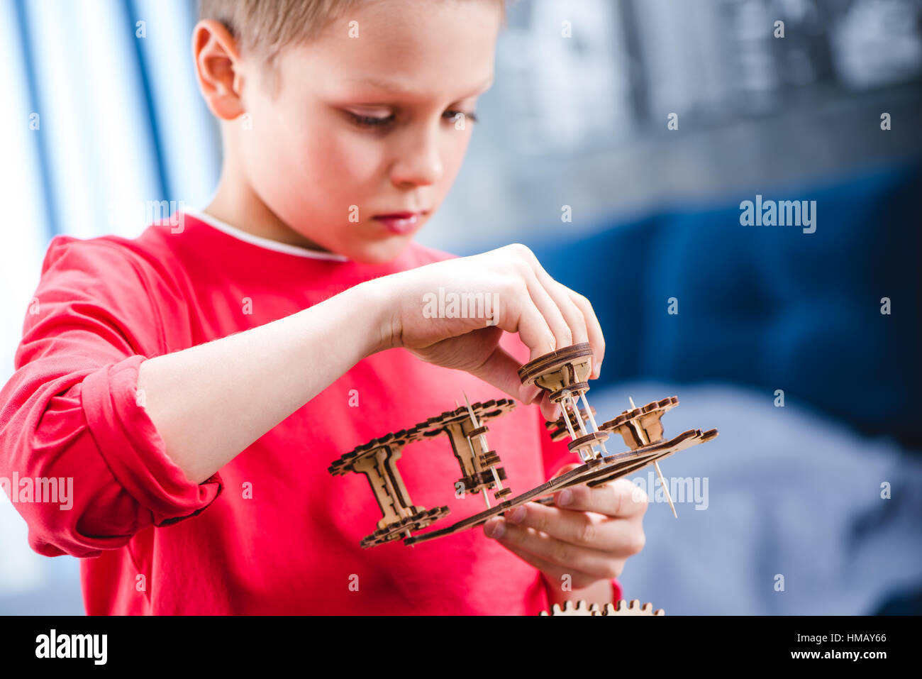 Kid holding wooden gear toy Stock Photo - Alamy