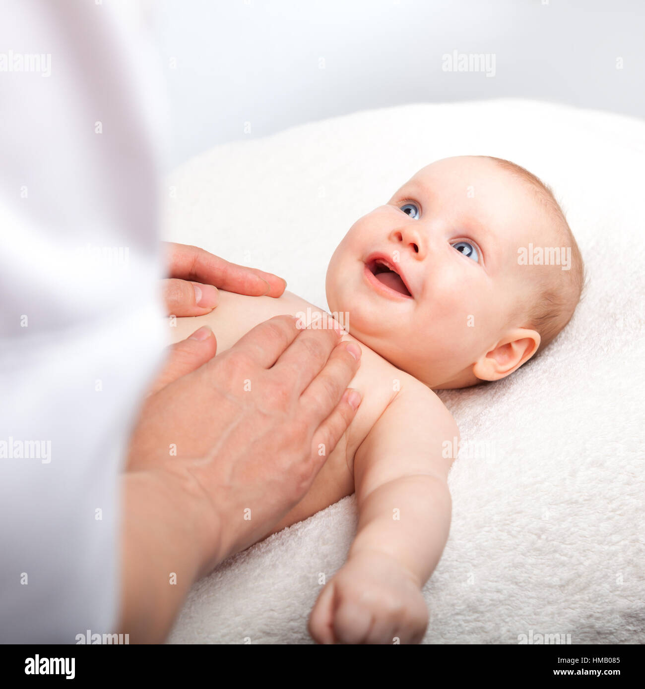 Three month baby girl is receiving chest massage from a female massage ...