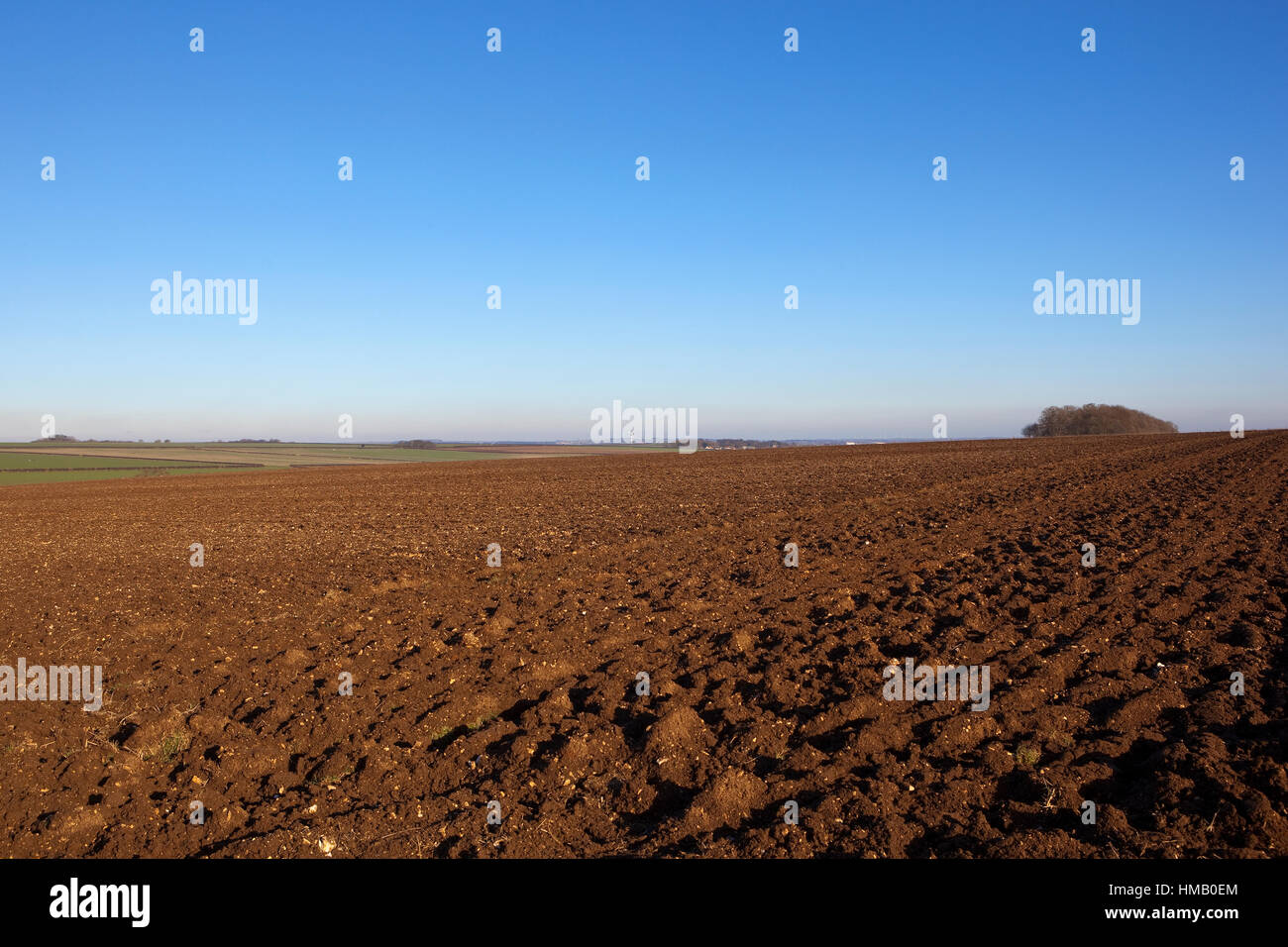 Blue sky over patterns and textures of fresh plow soil in the scenic ...