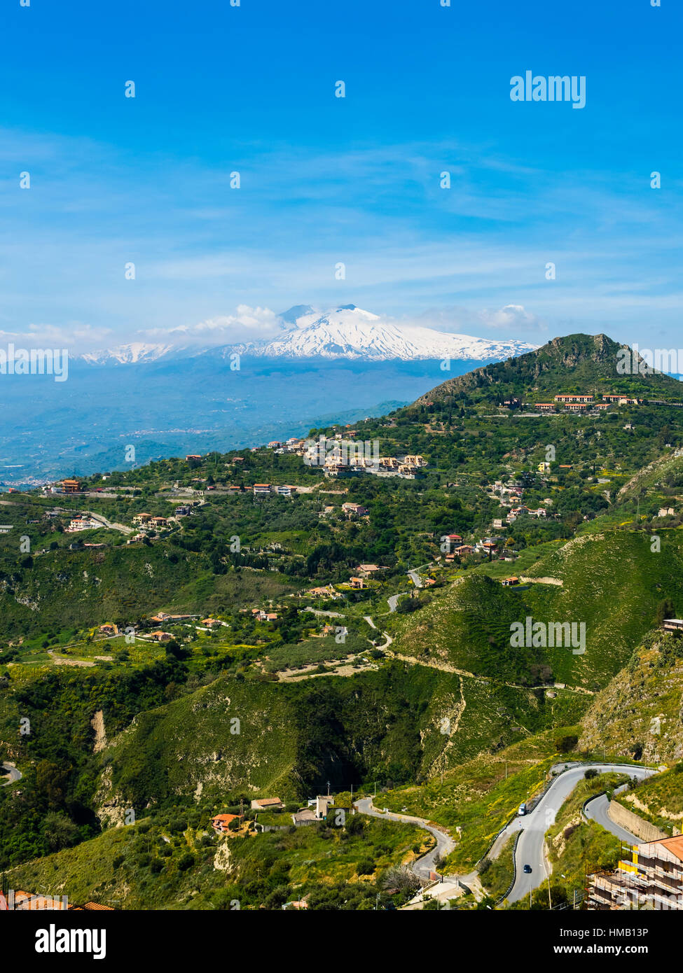 View of Taormina, snowy volcano Etna at back, Sicily, Italy Stock Photo ...