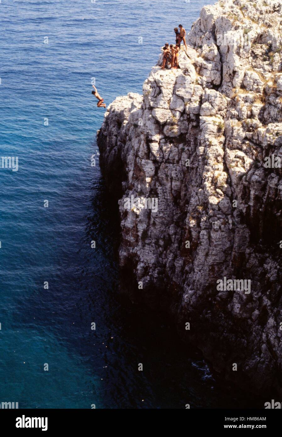 A boy diving off a cliff near Santa Maria di Leuca, Apulia, Italy Stock ...