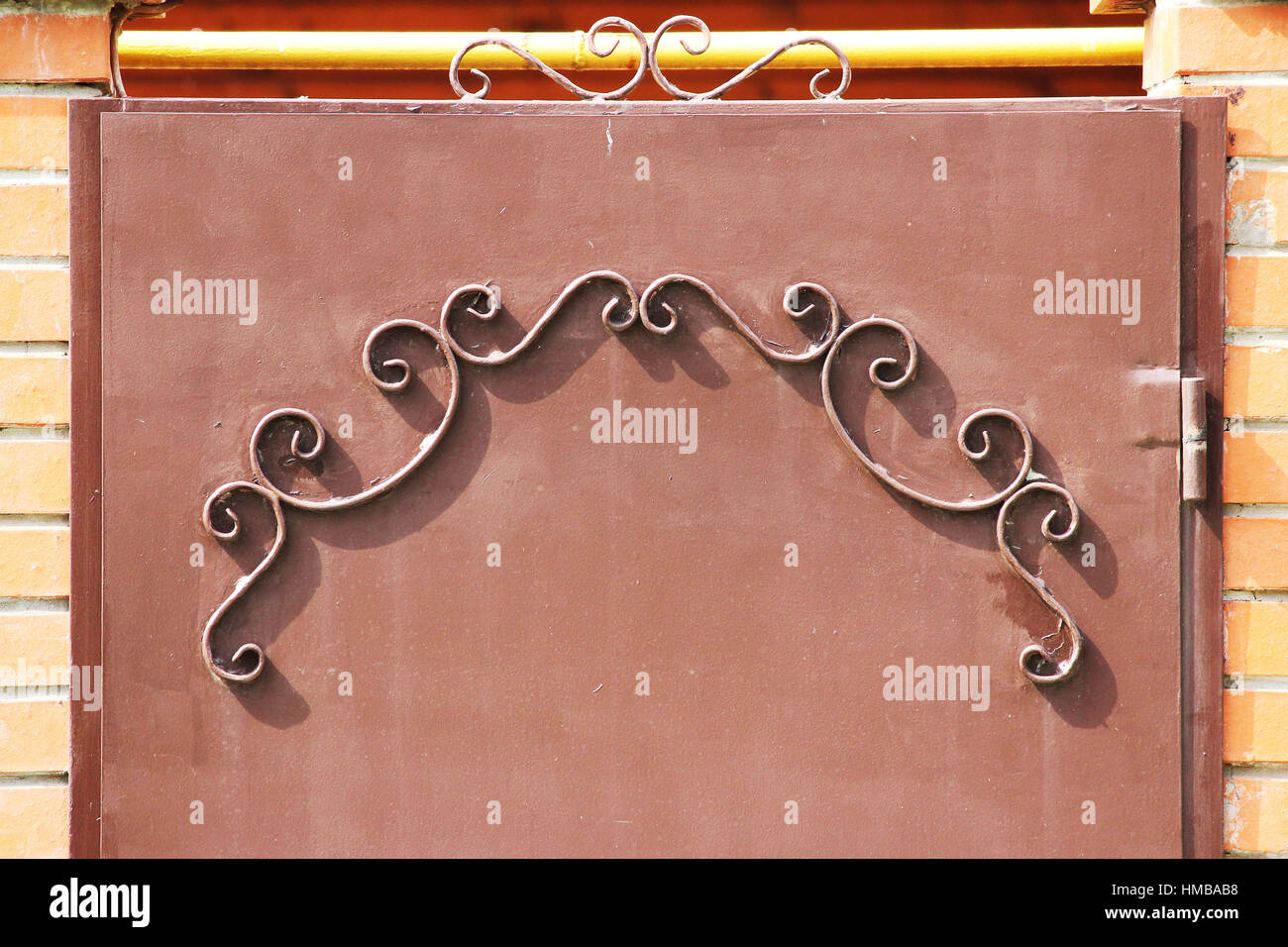 metal brown gates with a pattern in the form of curls covered with ...