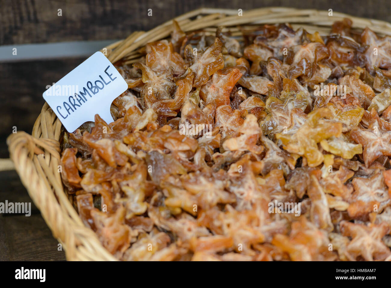 A basket full of sliced dried star fruit (carambola) on a market stall ...