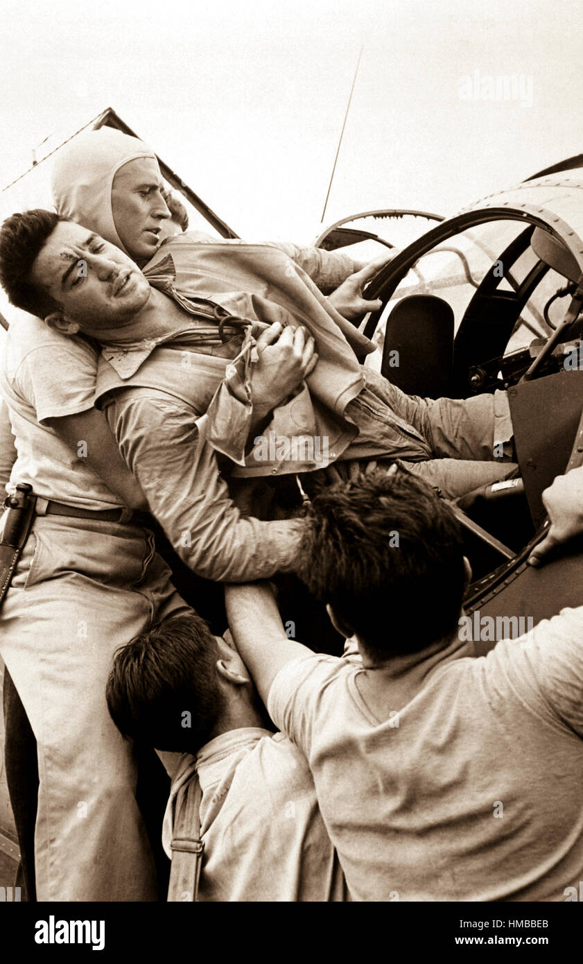 Crewmen lifting Kenneth Bratton (AOM) out of turret of TBF on the USS ...