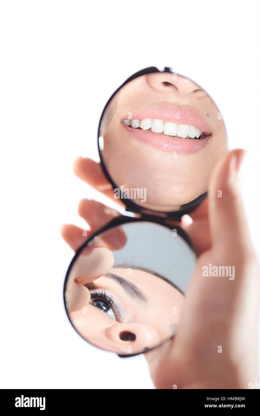 reflection on mirror of smile and eye while applying eyeshadow Stock ...