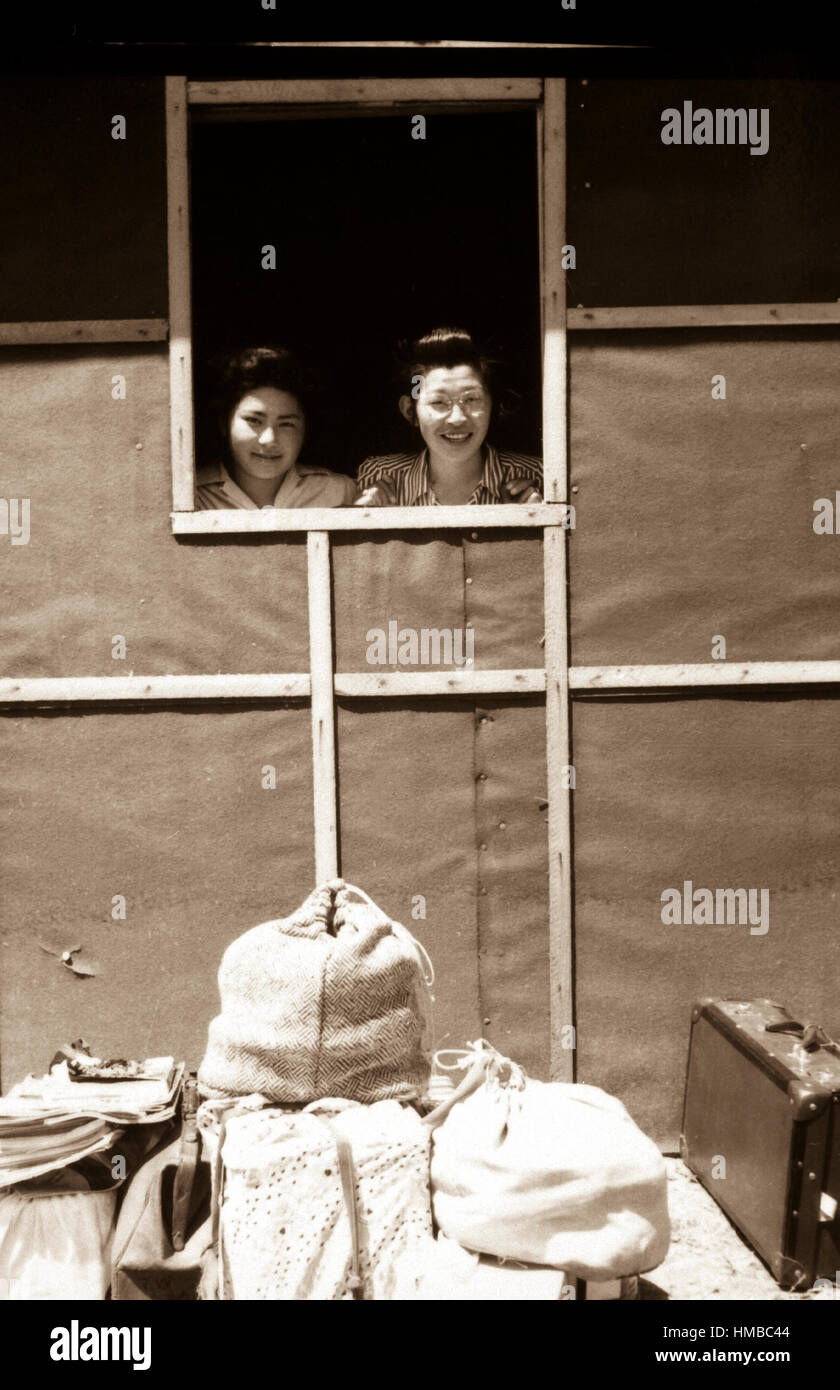 These two girls peer out of a window in their quarters just after their ...