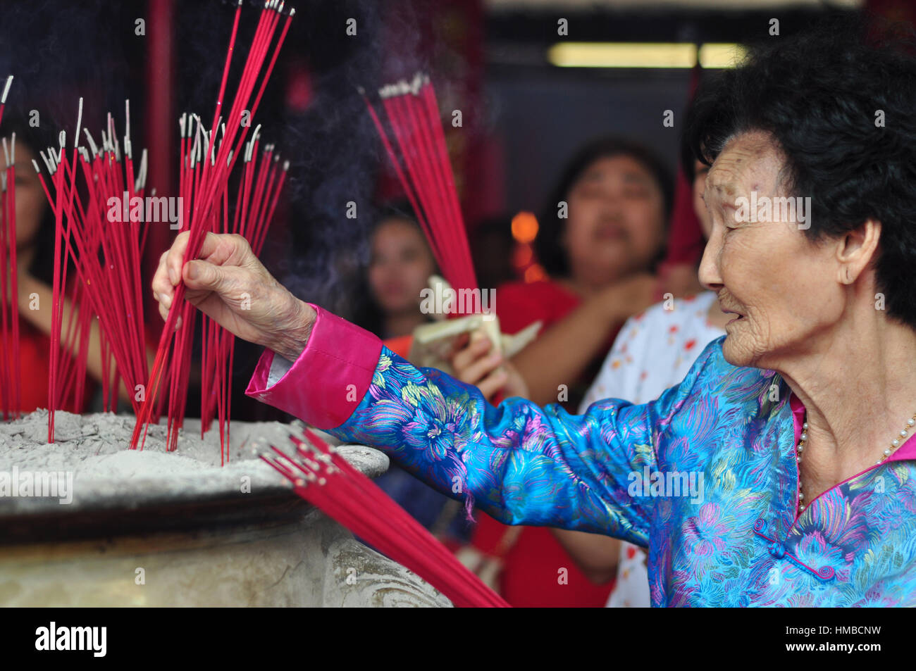 Jakarta, Indonesia - January 29, 2017: Chinese elder burn the incense ...
