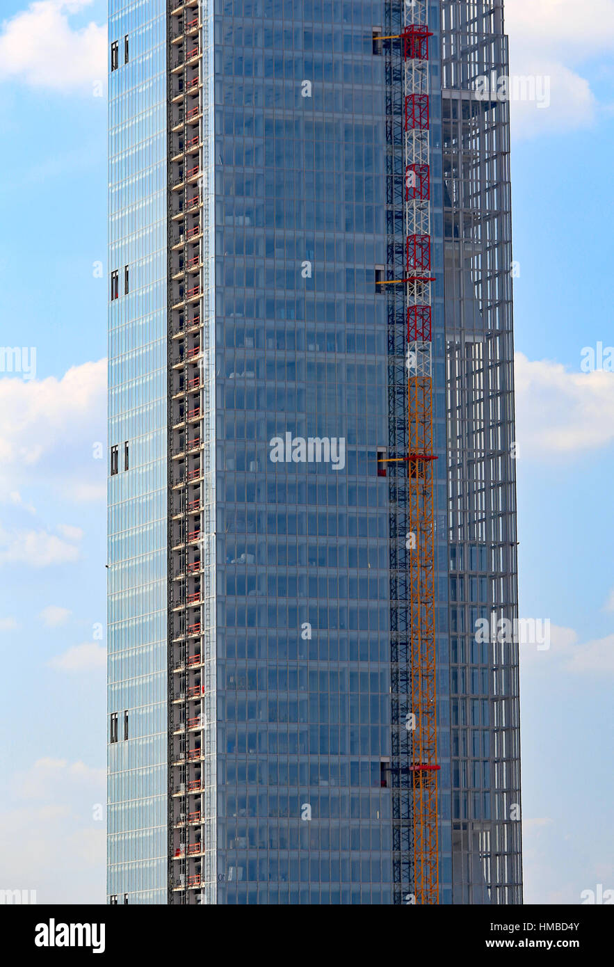 very tall skyscraper under construction made of glass and steel with a ...